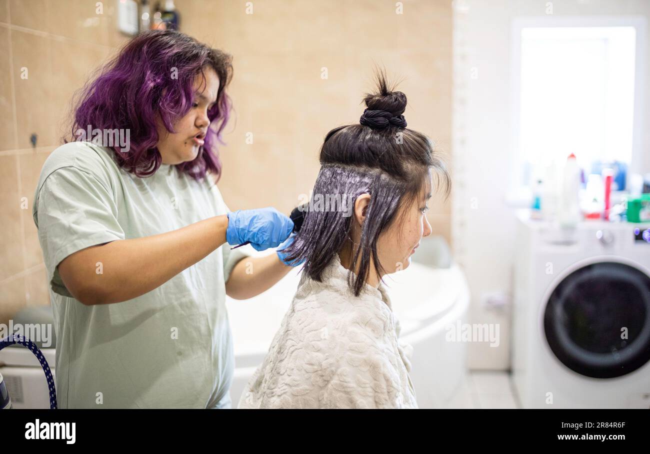 Teens dye their hair white, apply the dye to her hair at home Stock ...