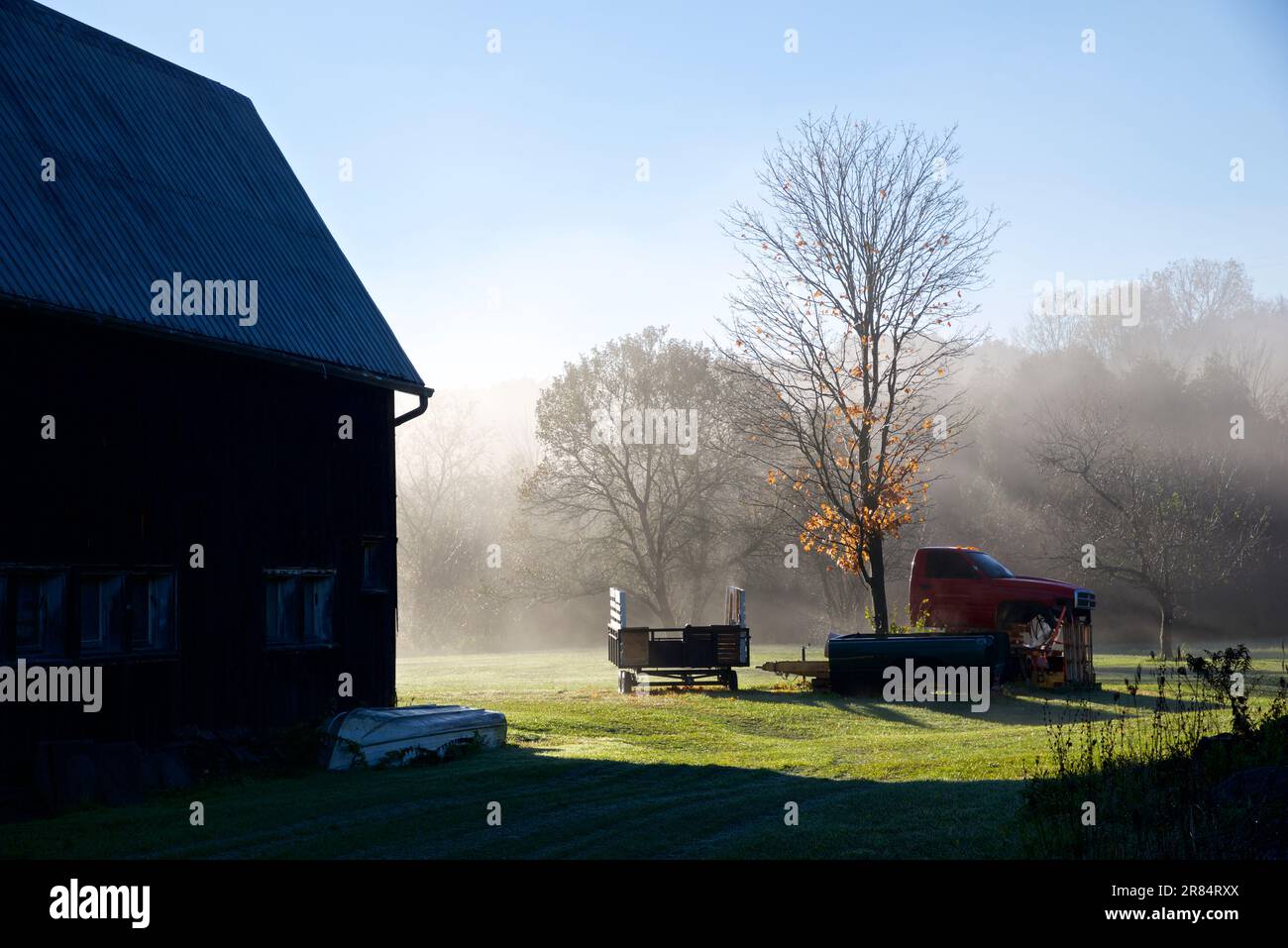 Farm barn with a red pick-up truck on a foggy day Stock Photo - Alamy