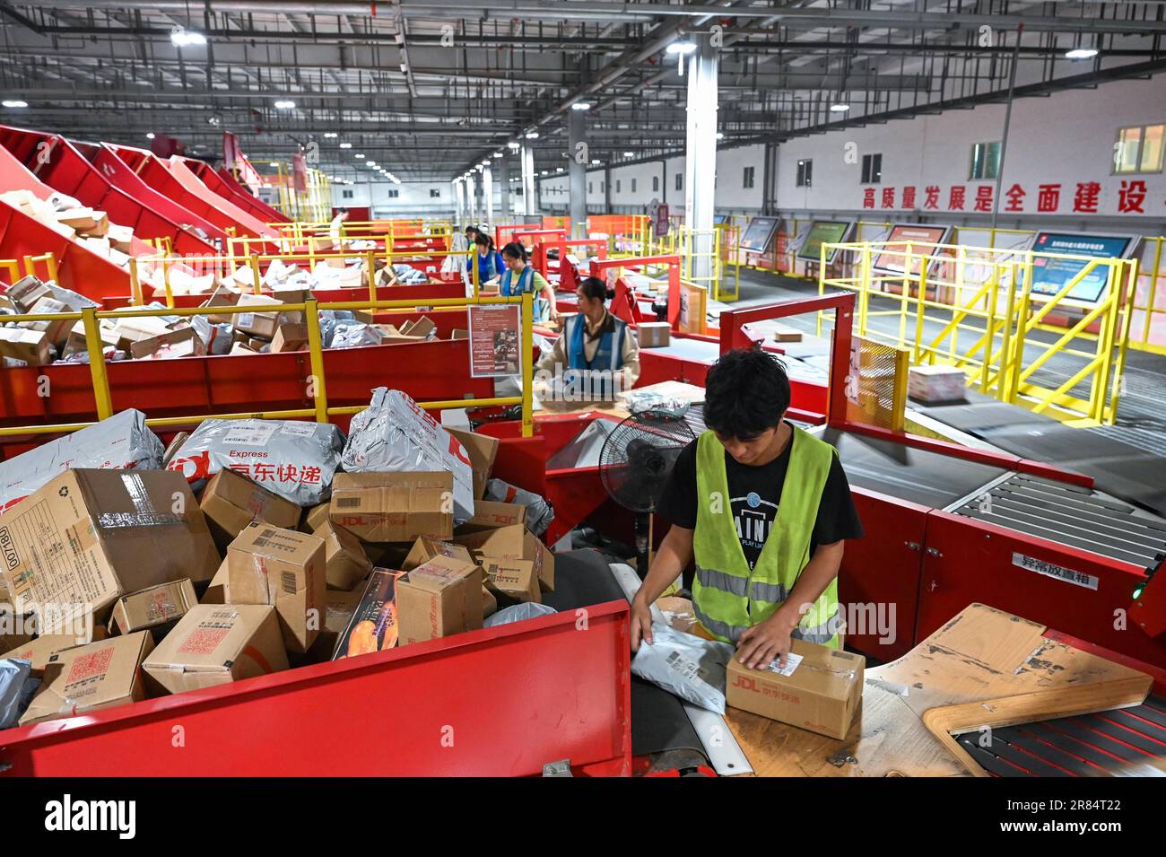 Workers sort parcels at a sorting center of JD Express in Chongqing ...