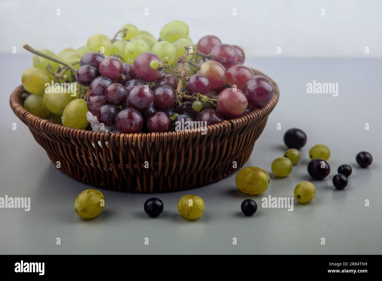 A wooden plate filled with clusters of grapes Stock Photo - Alamy