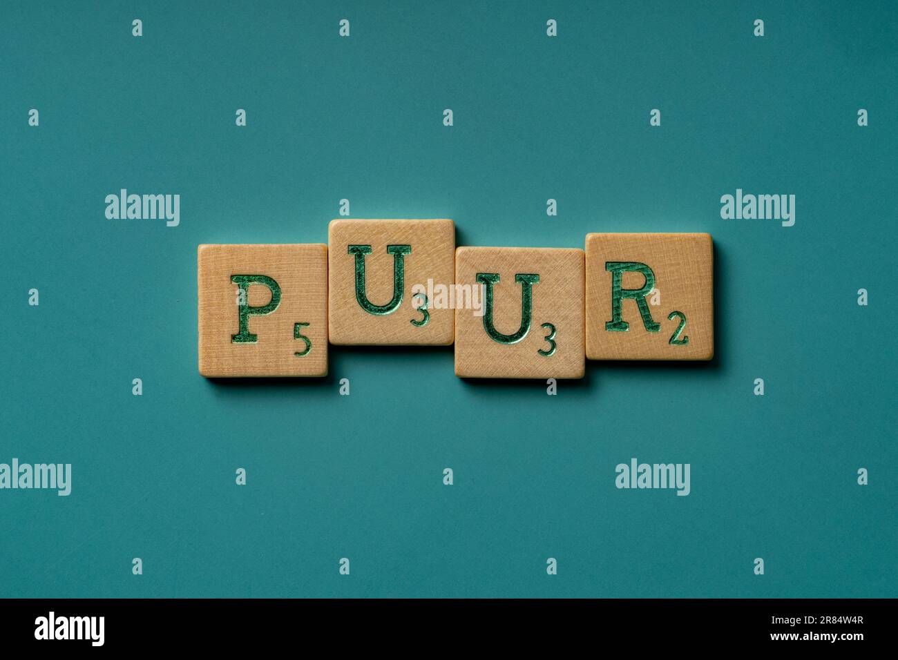 The wooden letters spelling the word puur (dutch for pure) on a blue ...