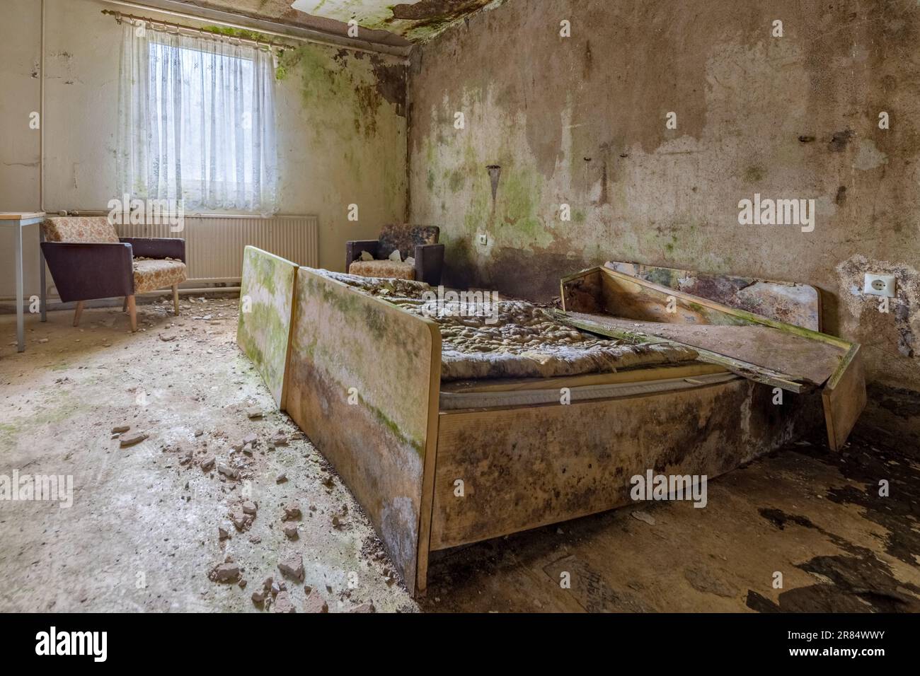 Severe decay in a room with a double bed and a chair Stock Photo - Alamy