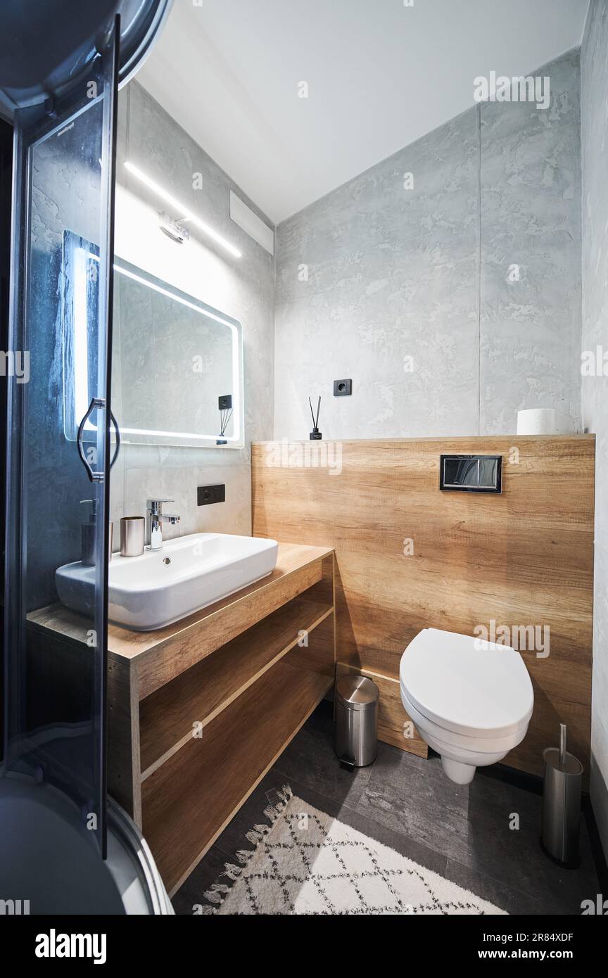 Clean, minimalist grey bathroom in slate with ceramic sink on wooden ...