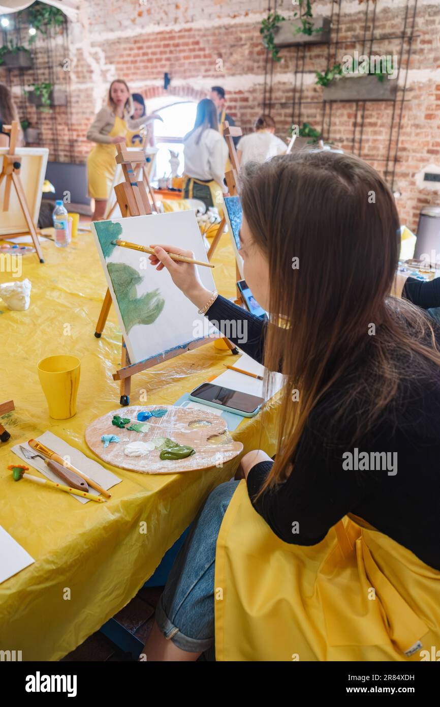 Woman paint brush canvas friends hi-res stock photography and images ...