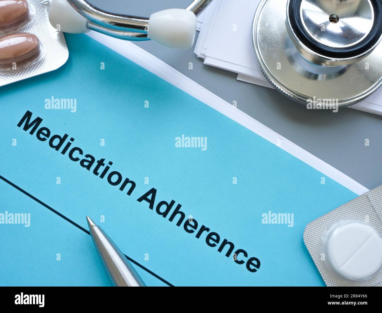 Pile of papers about Medication adherence on the desk Stock Photo - Alamy