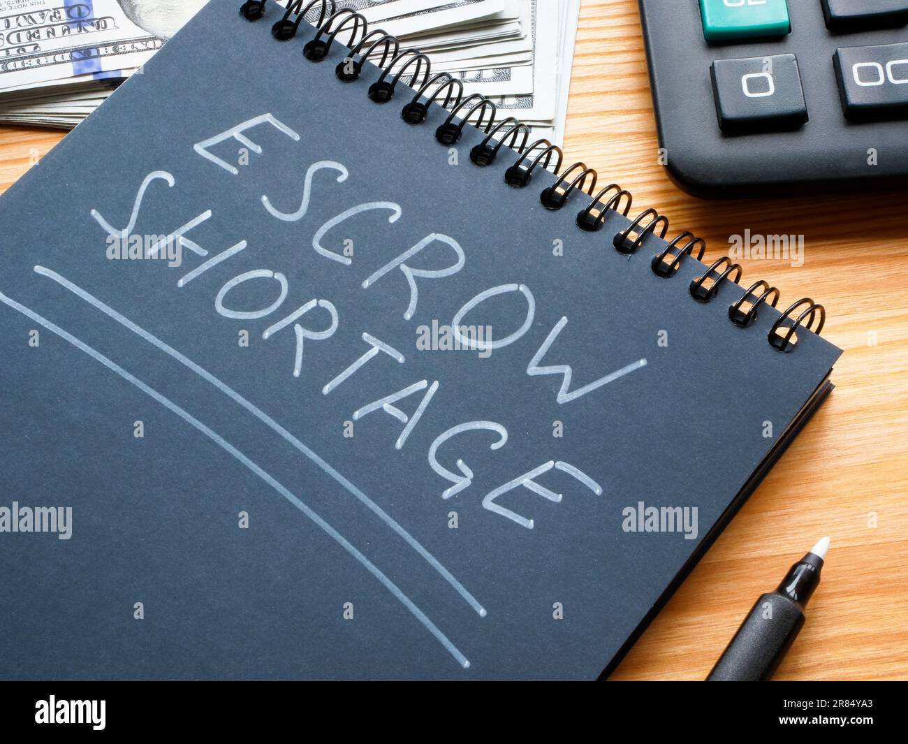 The entry Escrow shortage was made in a notebook with a white marker ...
