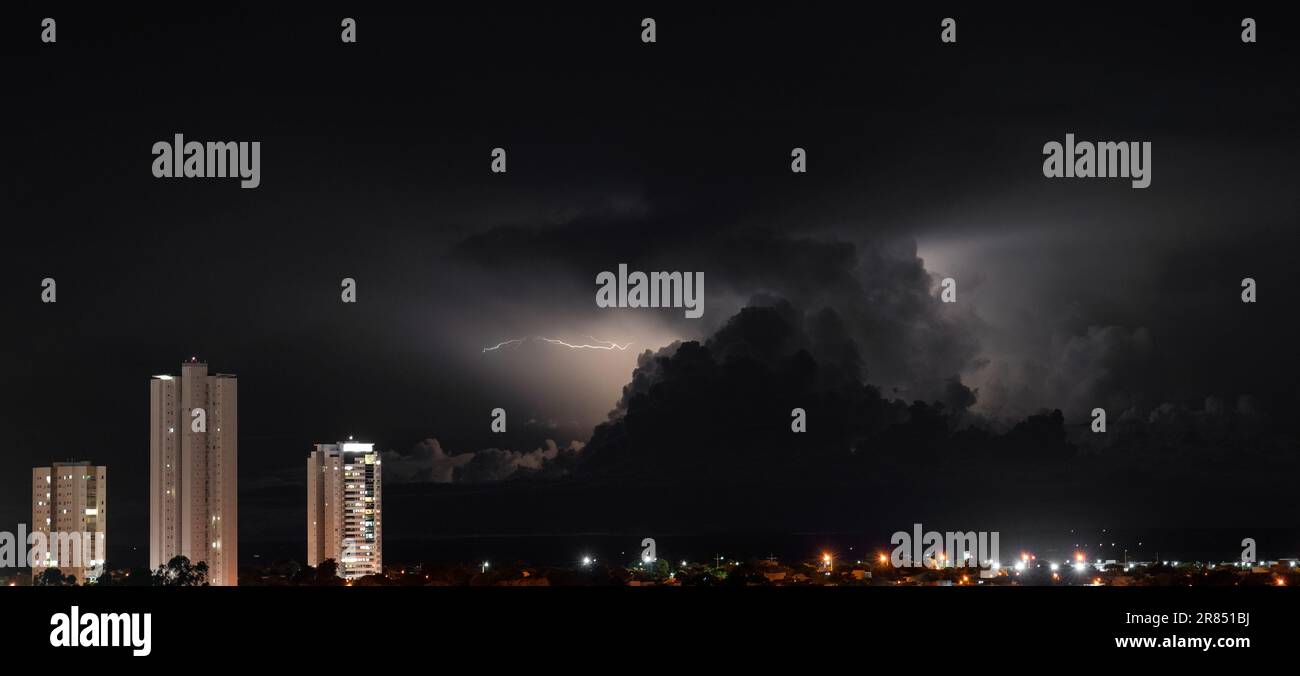 Three Skyscrapers Rise Above the Dark Cityscape During a Stormy Night ...