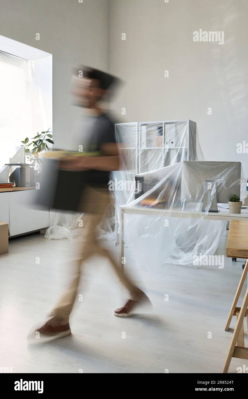 Blurred motion of man carrying things in box during the move in office ...