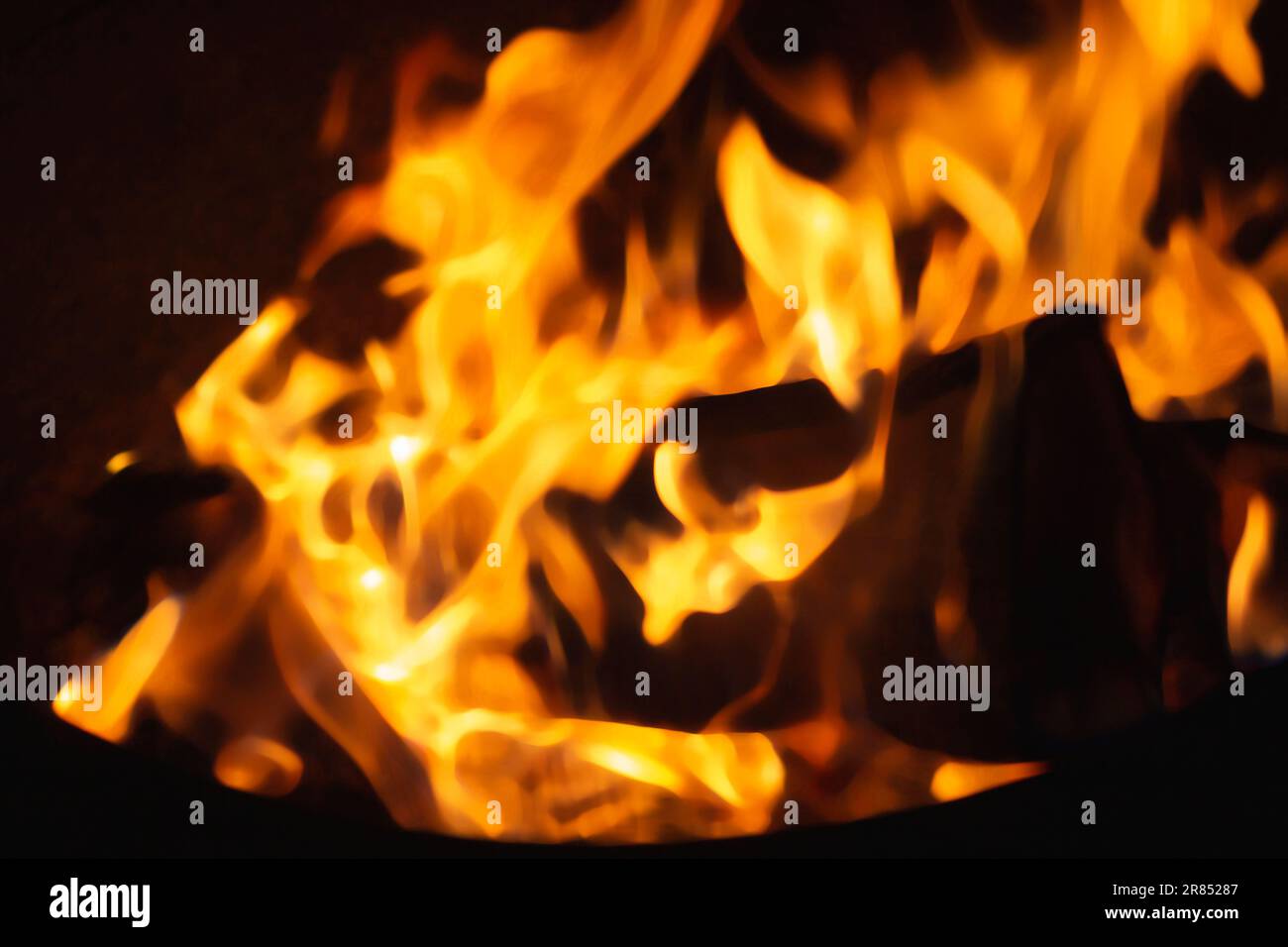 Blurred background with Burning firewood in the fireplace close up ...