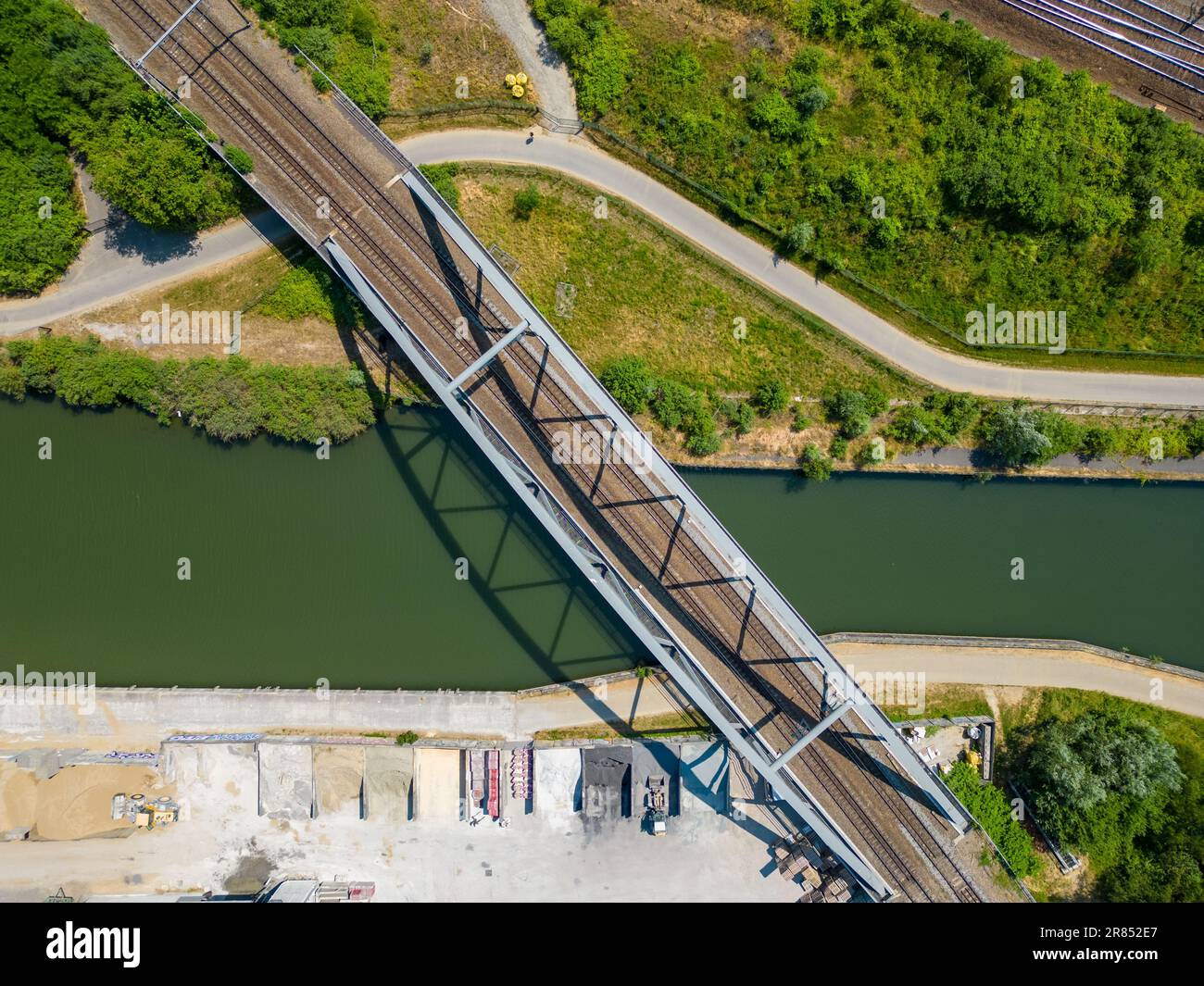 Aerial view of metal railway bridge over the water of a river, with the ...