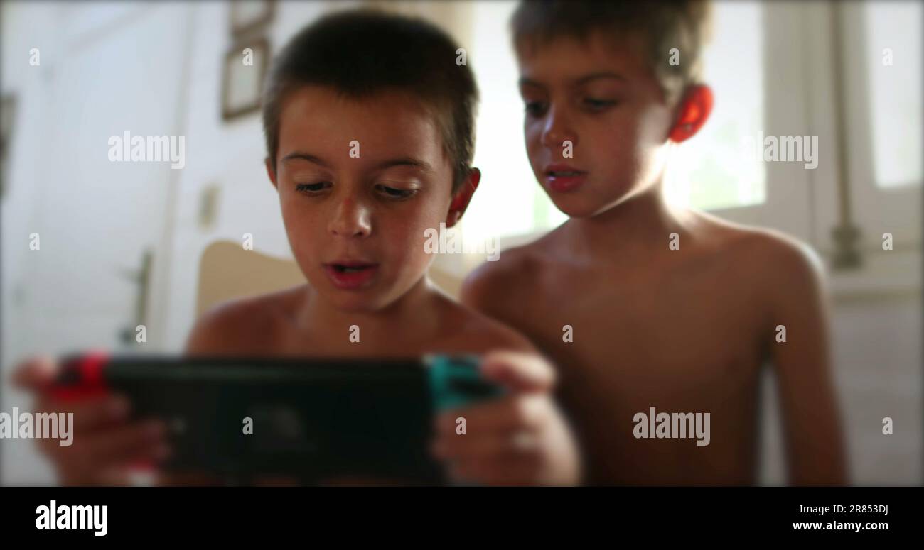 Two siblings sharing video-game screen, brother playing game online ...
