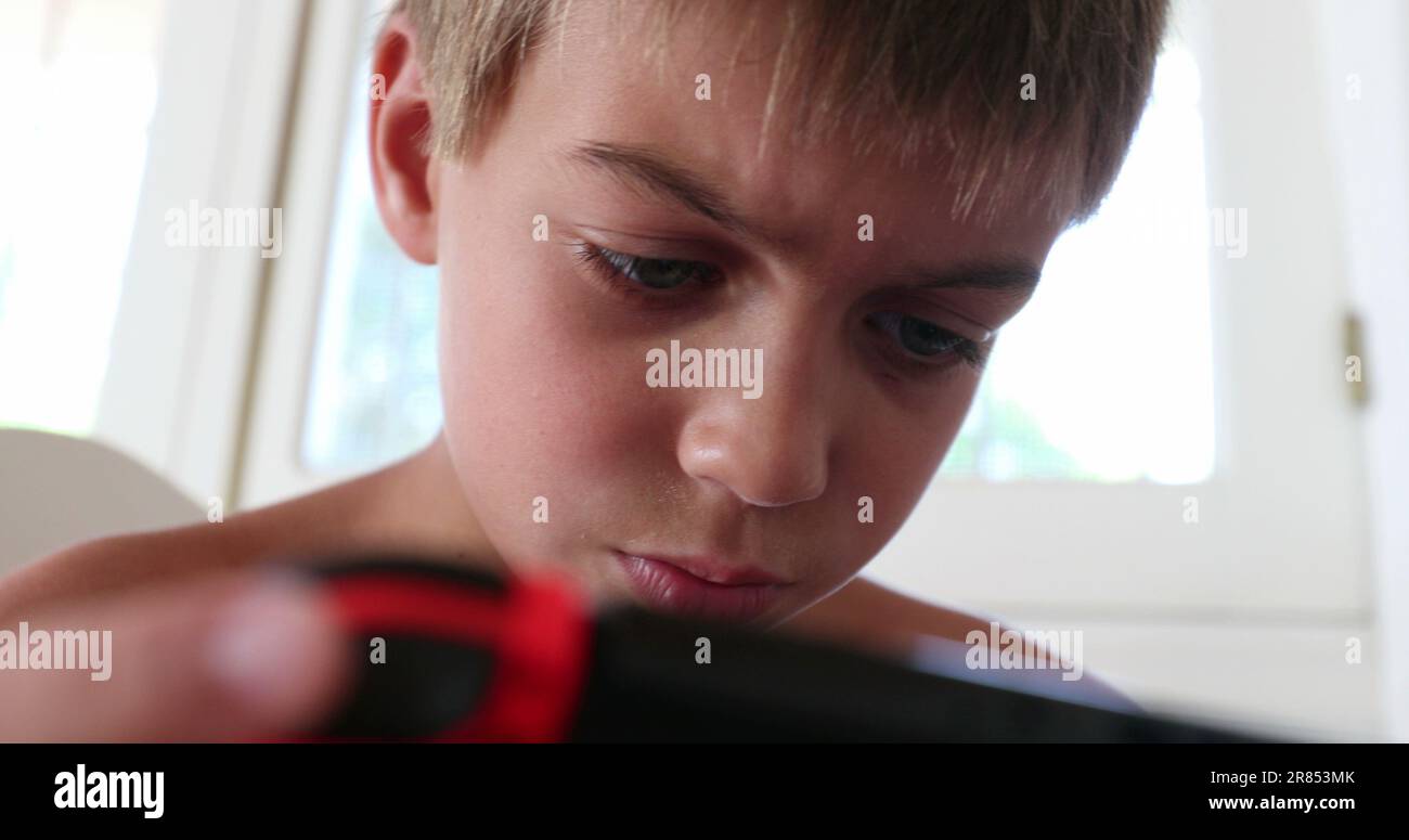 Young boy child holding game controller playing online. Close-up of kid ...