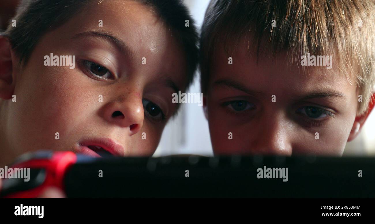 Two brothers playing game with controller.Sibling watching and sharing ...