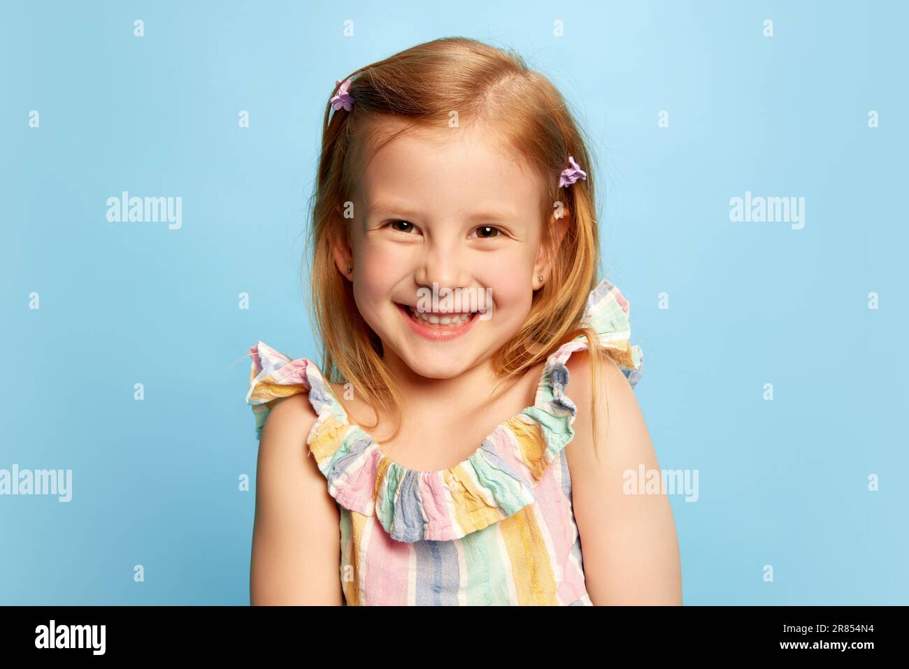 Close-up portrait of pretty little girl, redhead child looking at ...