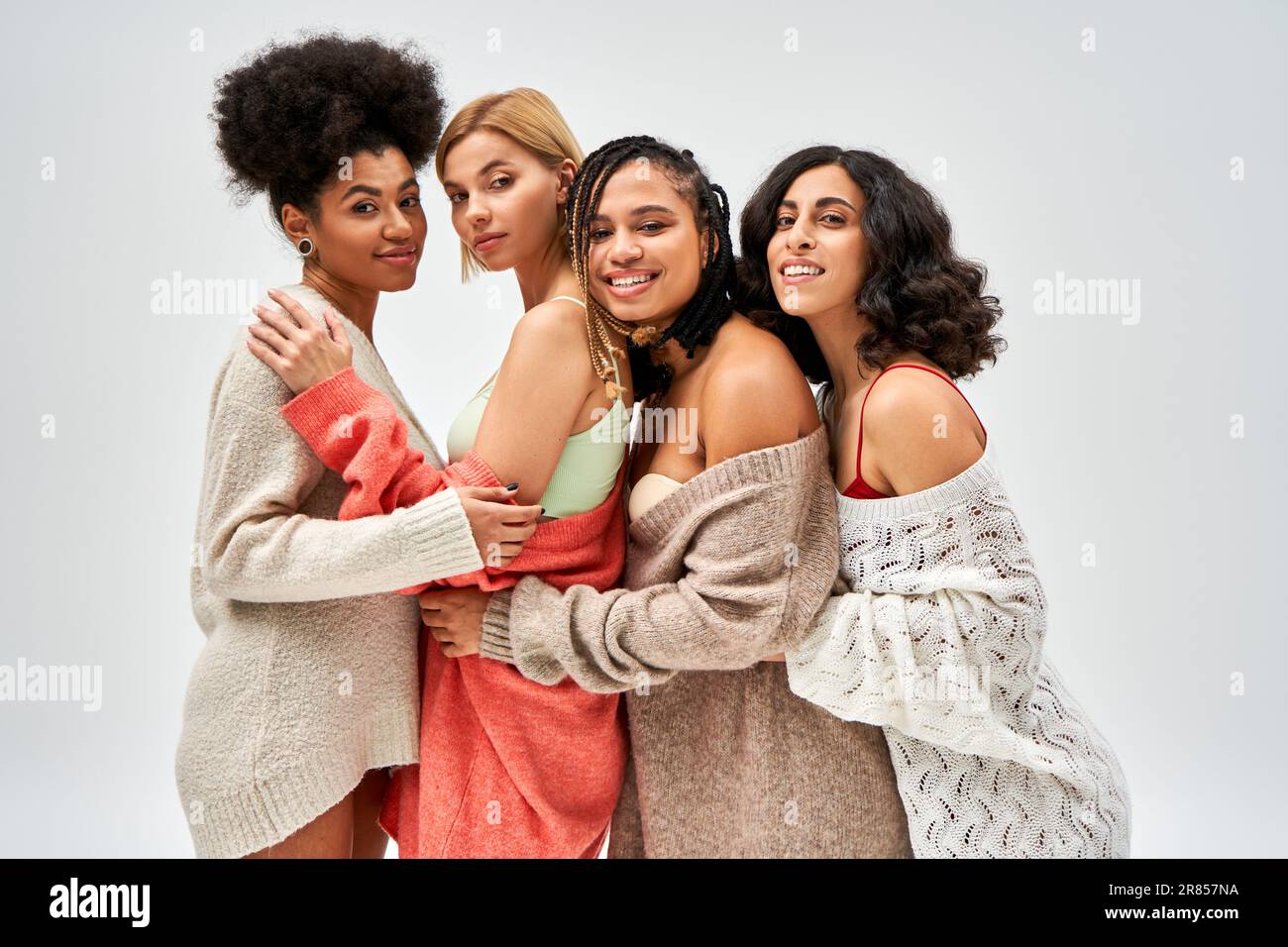 Portrait of stylish and confident multiethnic women in knitted sweaters ...