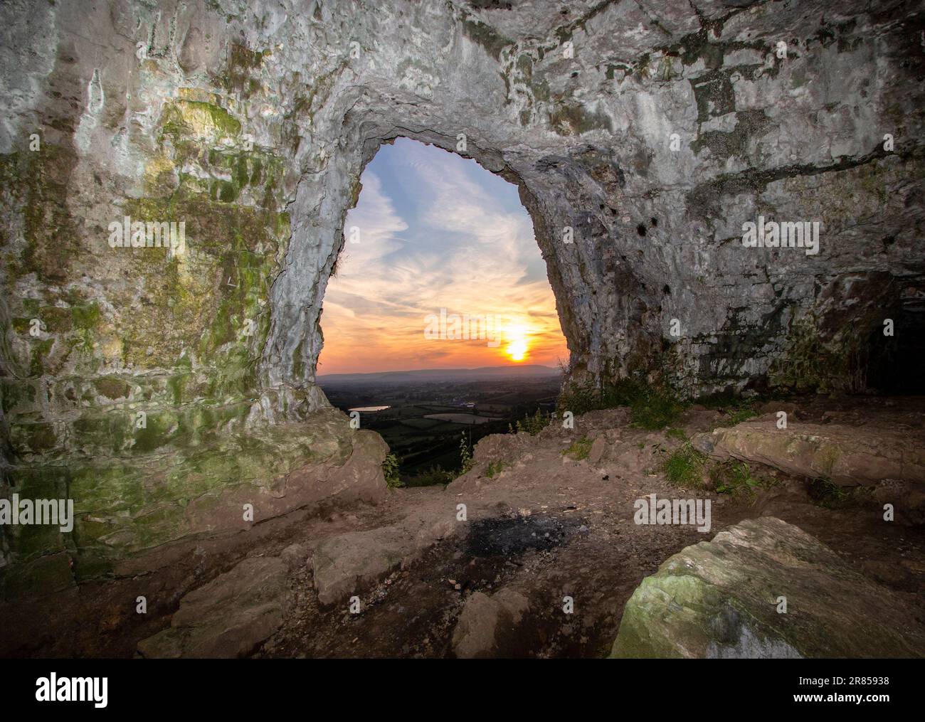A scenic view of sunset over a landscape seen from a cave Stock Photo ...