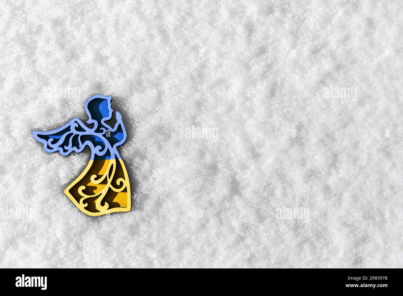blue and yellow toy angel on white snow Stock Photo - Alamy