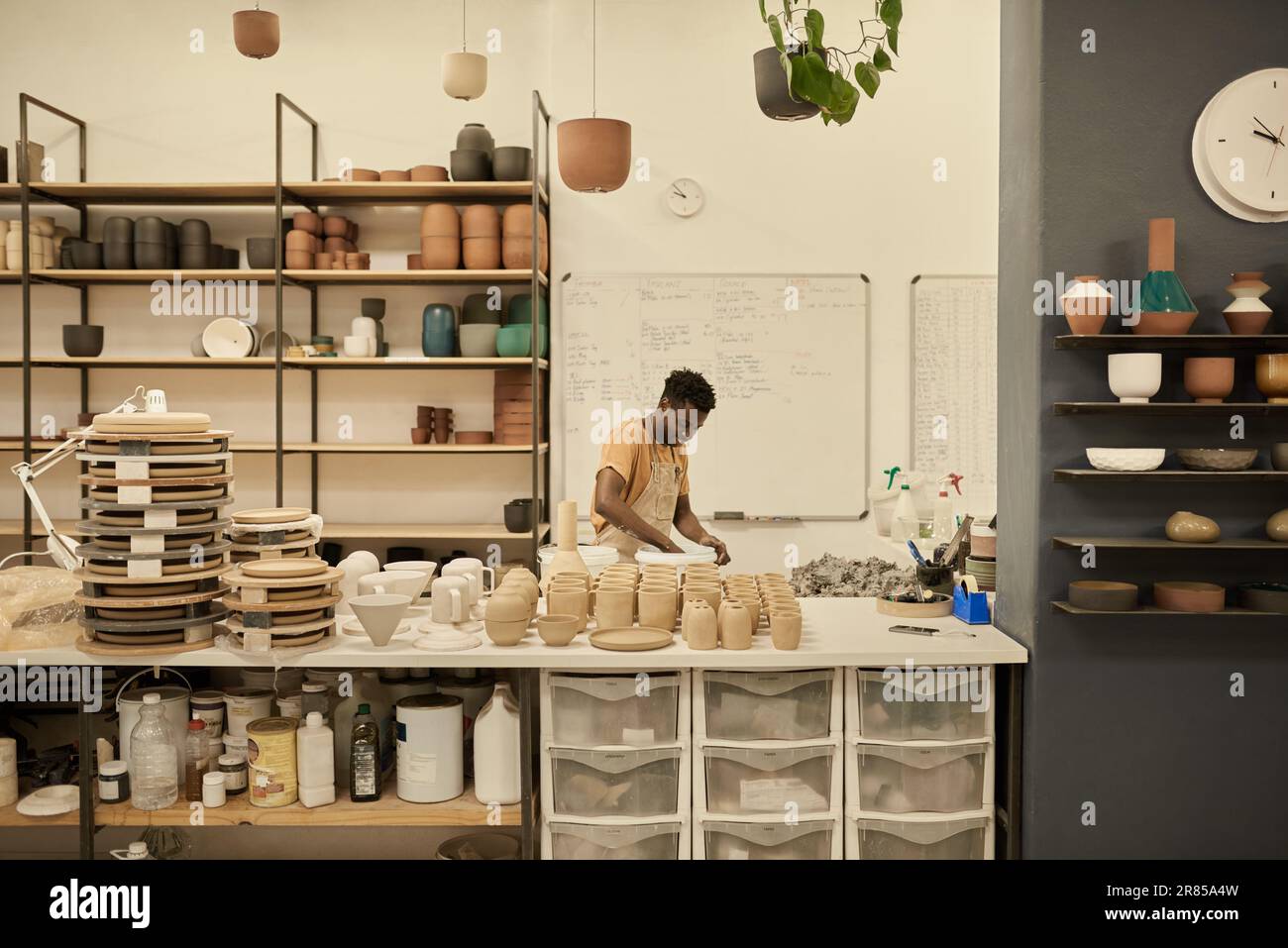 Smiling African ceramist working at a bench in a pottery studio Stock ...