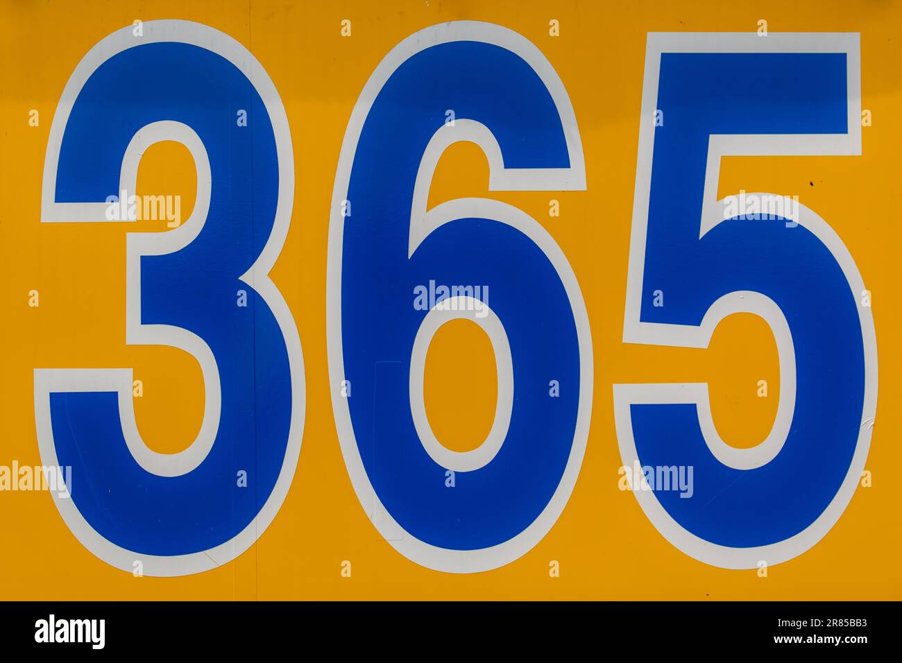 365 foot ft baseball field distance sign in yellow and blue mounted on the outfield fence Stock ...