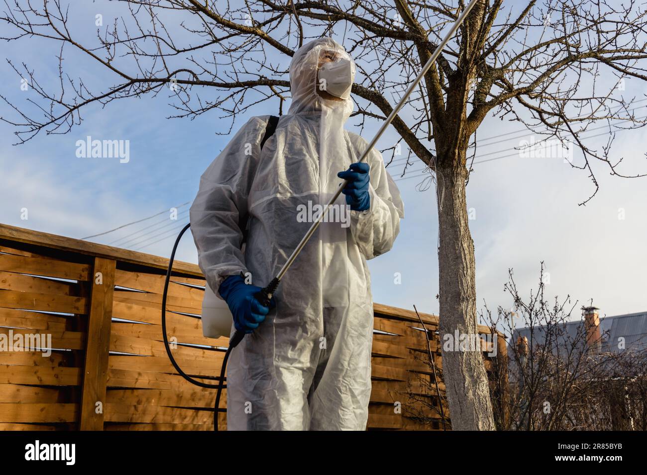 Using chemicals in the garden orchard gardener applying an insecticide ...