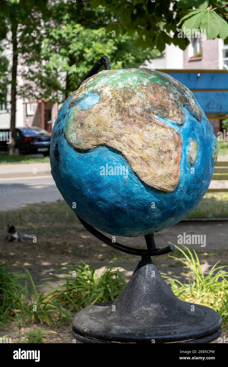 photo metallic globe sculpture in the street background is blurred ...