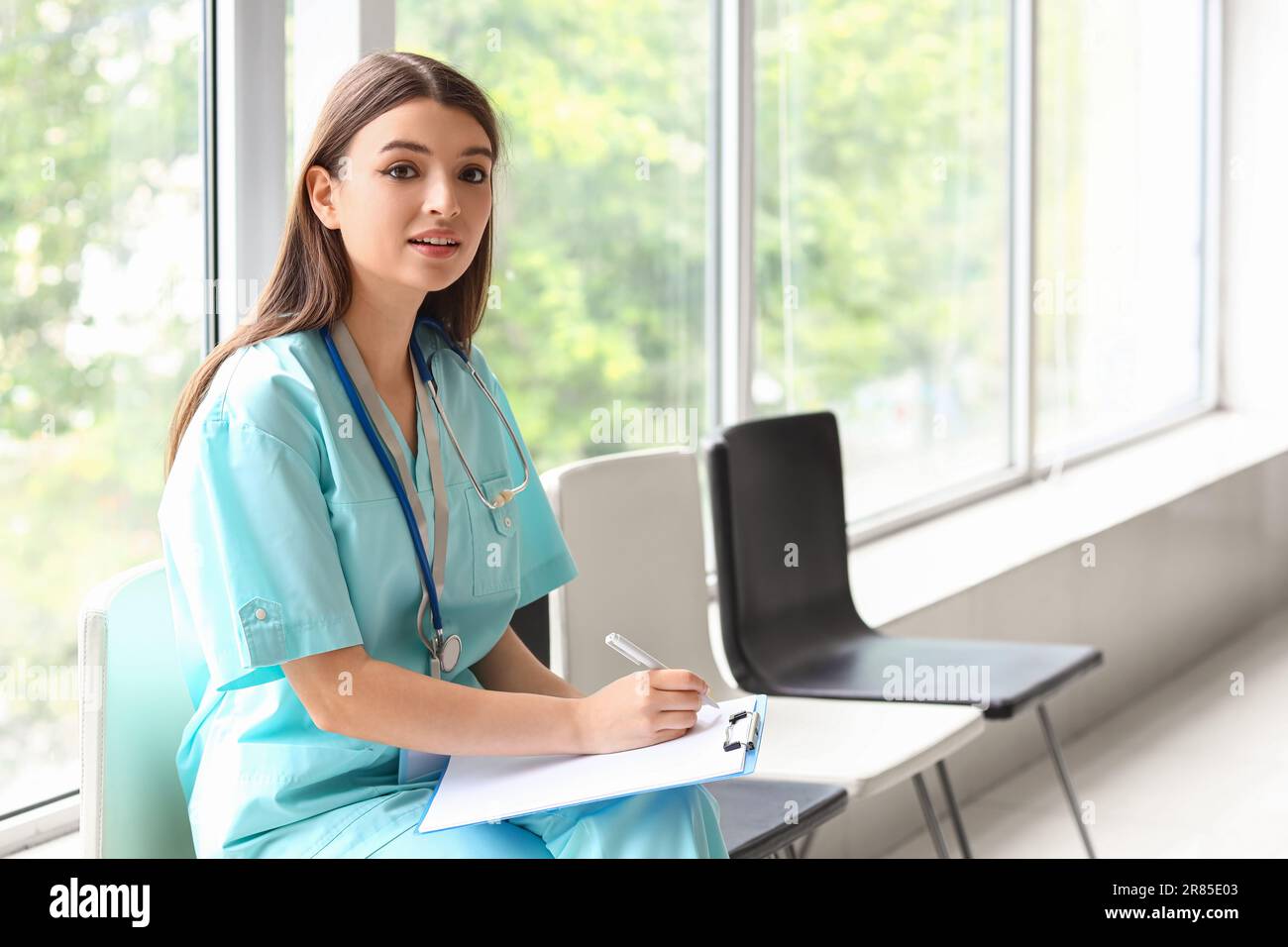 Female medical intern writing in clipboard at hospital Stock Photo - Alamy