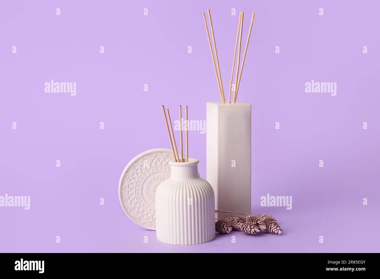 Bottles of reed diffuser and flowers on purple background Stock Photo ...