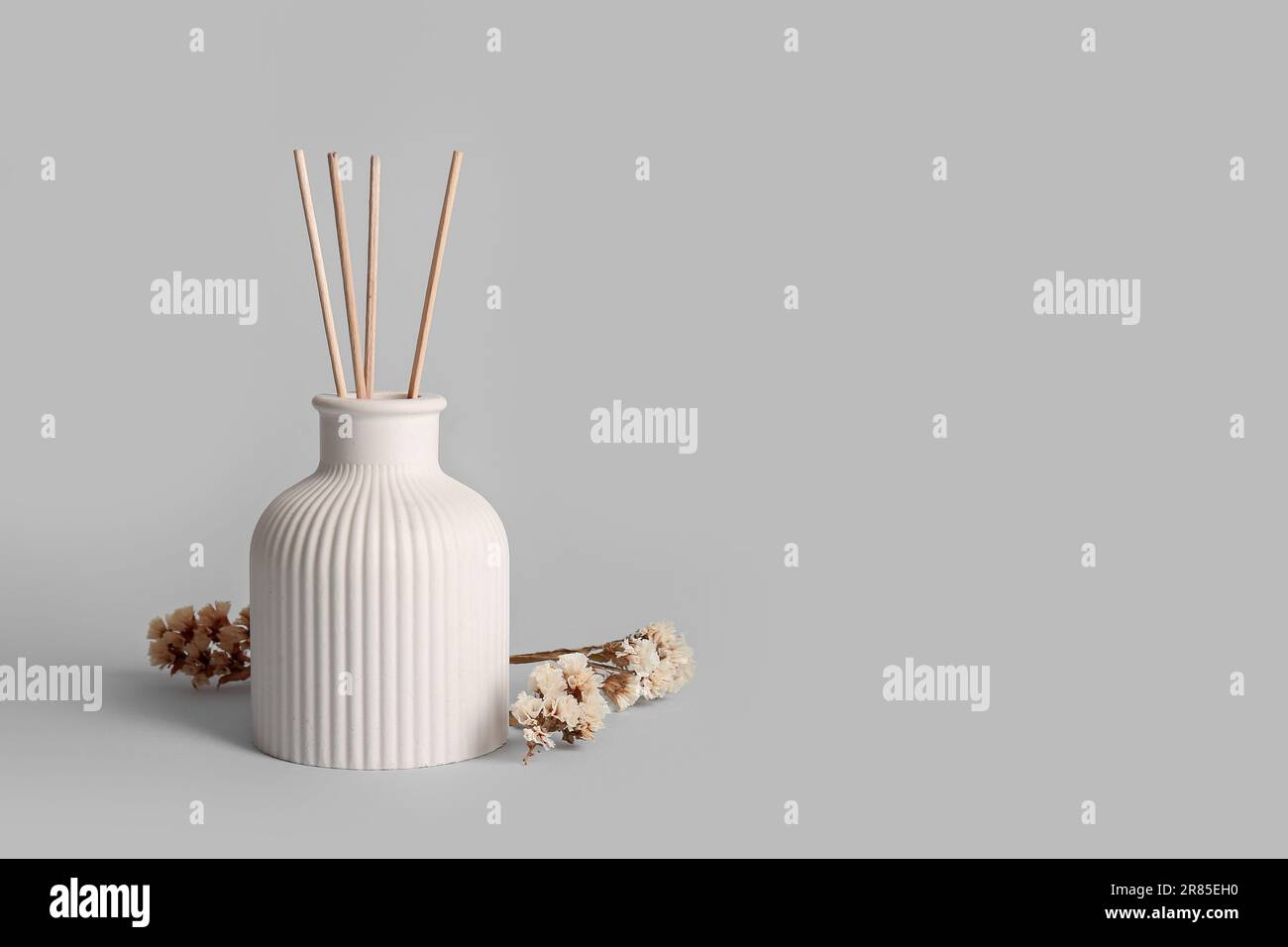 Floral reed diffuser and flowers on grey background Stock Photo - Alamy