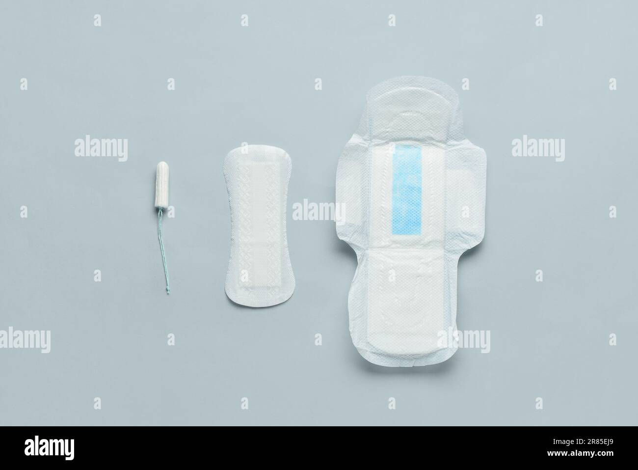 Different menstrual pads and tampon on grey background Stock Photo - Alamy