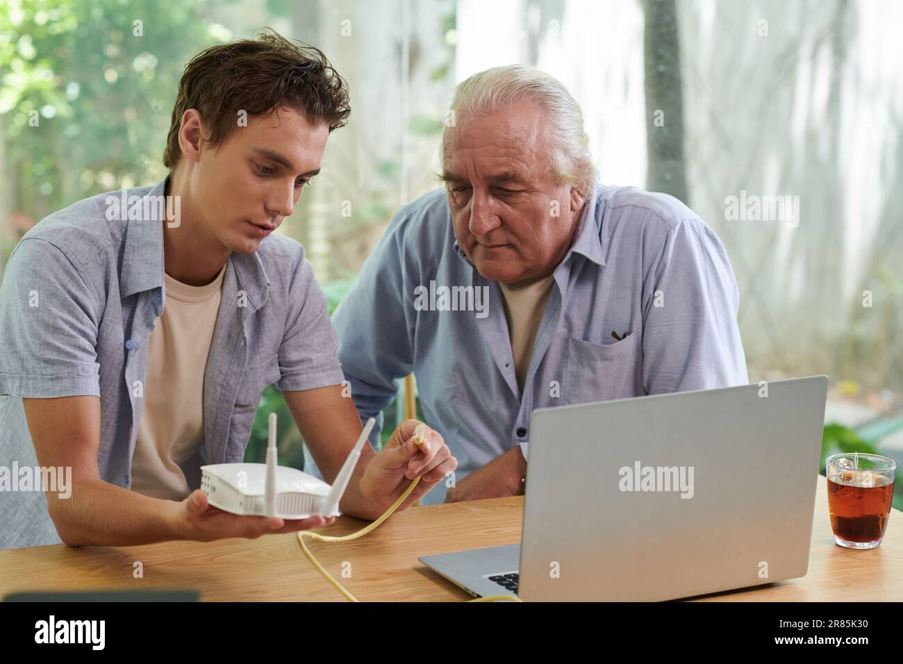 Young man setting wi-fi router to establish internet connection for ...