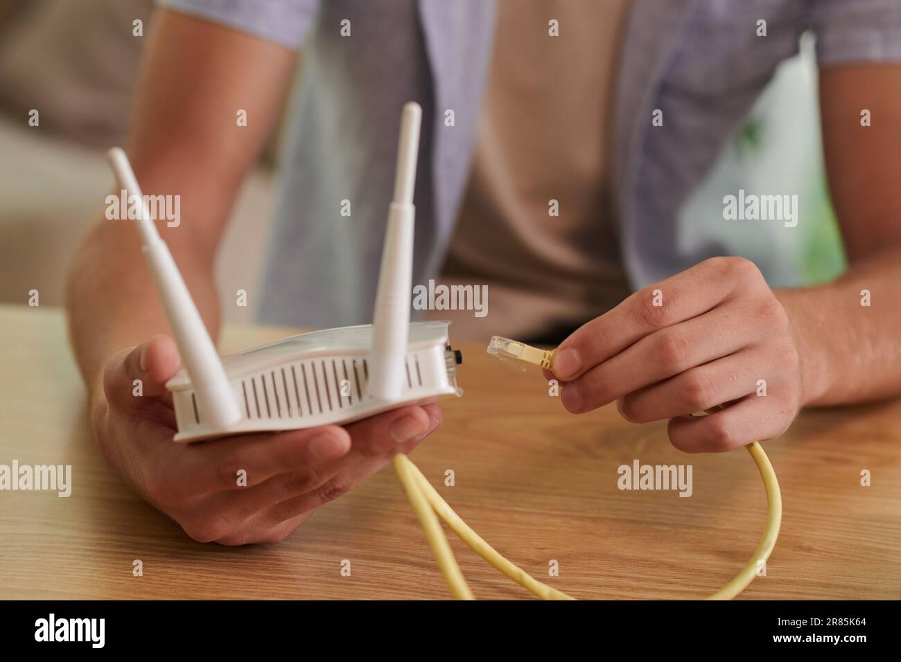 Hands of man inserting ethernet cord in wi-fi router Stock Photo - Alamy