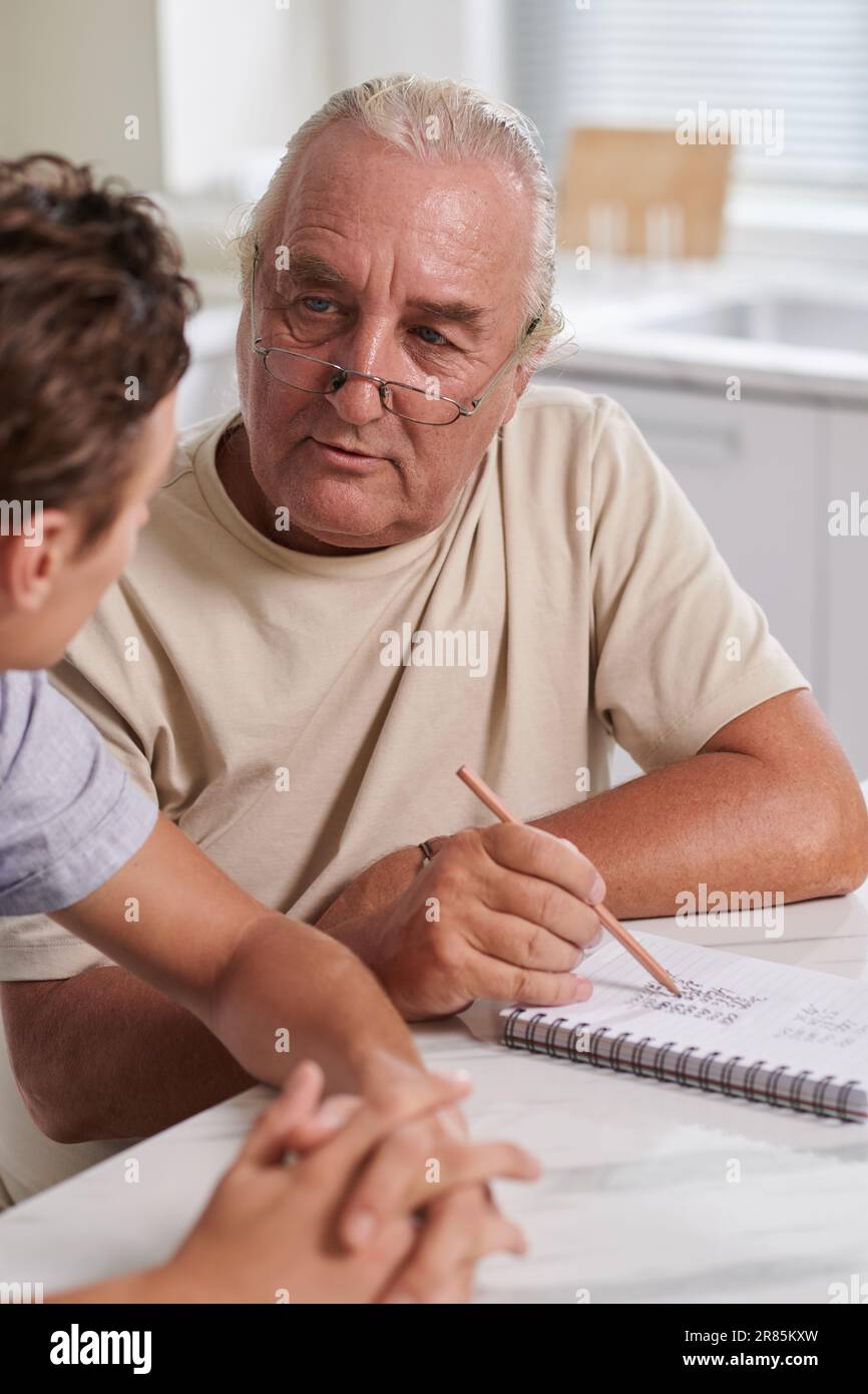 Senior man discussing family budget with adult son, teaching his how to ...