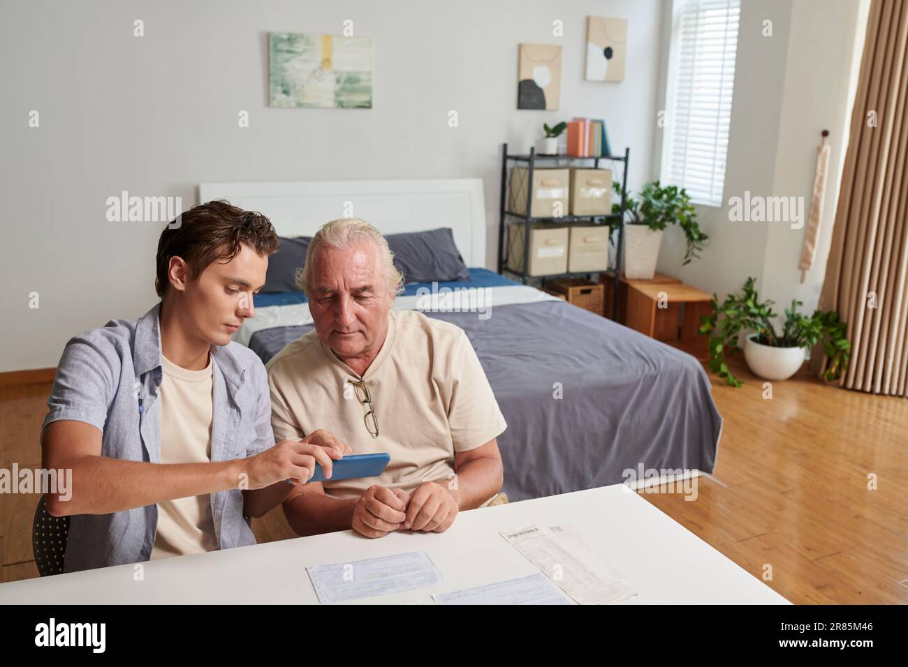 Grandson showing grandfather how to pay utility bills online Stock ...