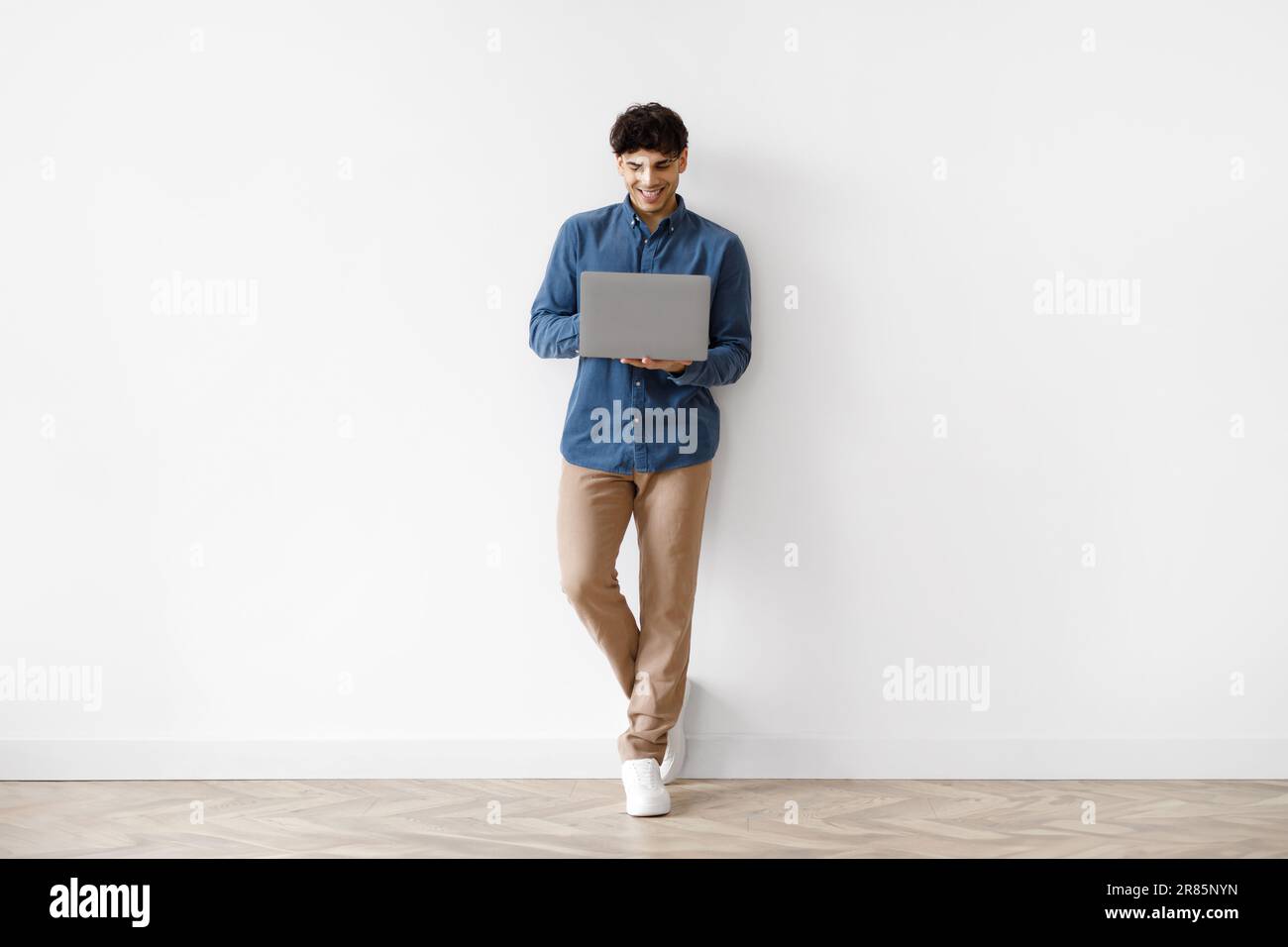 Happy Middle Eastern Freelancer Guy Using Laptop Computer Standing ...