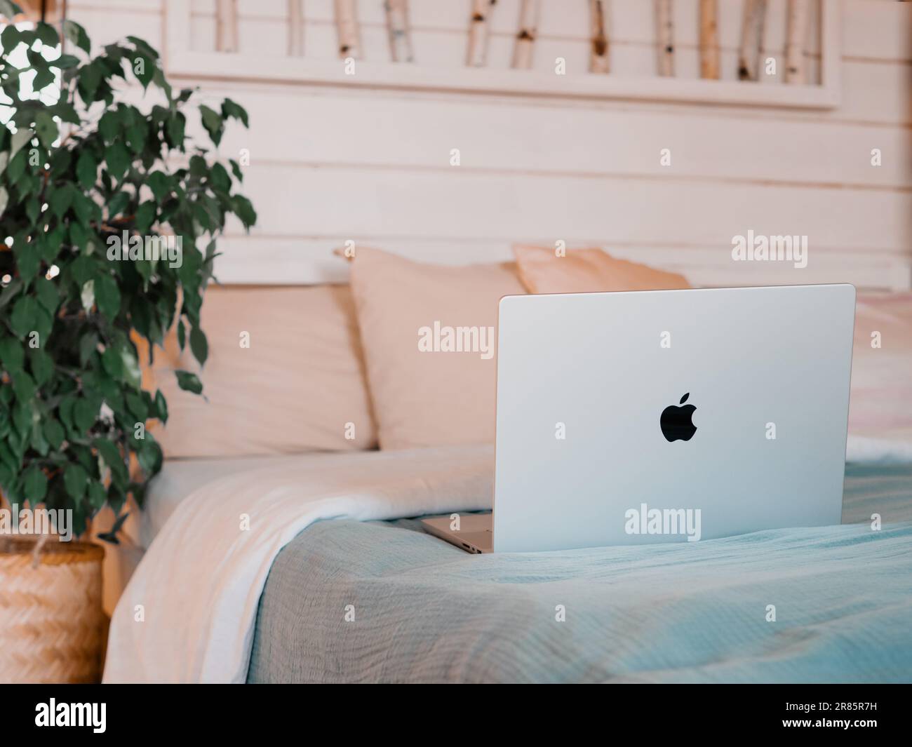 Macbook on bed in country house bedroom interior background. Silver ...