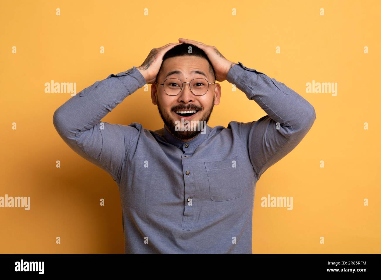 Portrait Of Surprised Aisan Man Touching Head And Opening Mouth In ...