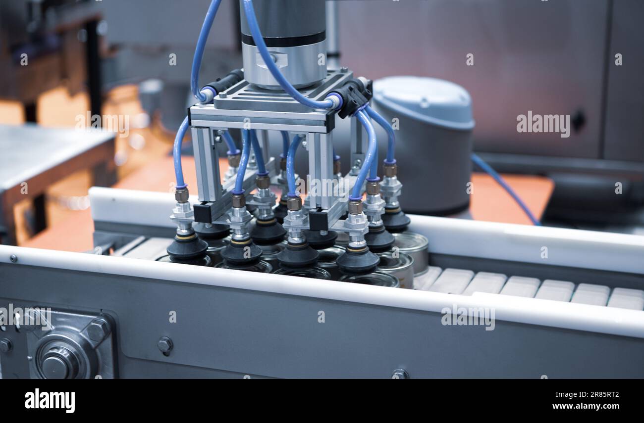 Automated robot arm lifting food can to conveyor belt in food industry ...