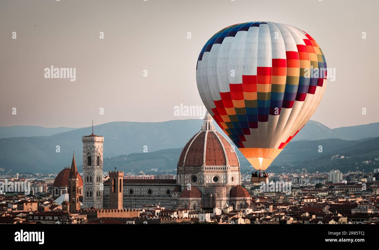 Hot air balloon rising in front of the Duomo in Florence during sunrise ...