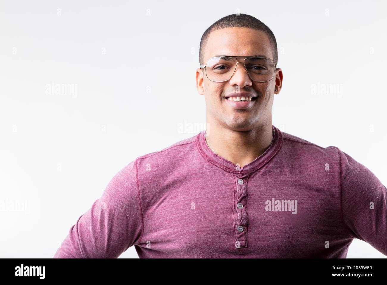 Portrait of a joyful young black man, stylishly donning metallic-framed ...