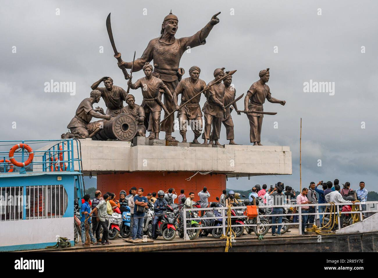 Guwahati, India. 17th June, 2023. People ride in a ferry as dark clouds ...