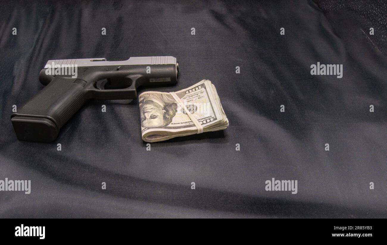 Photo og a gun and money on black background with copy space on right ...
