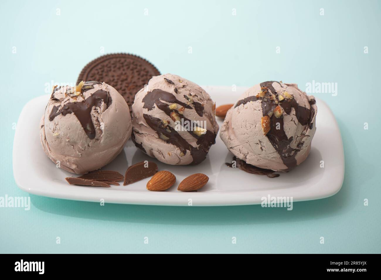 Chocolate ice cream in balls decorated with nuts and chocolate icing ...