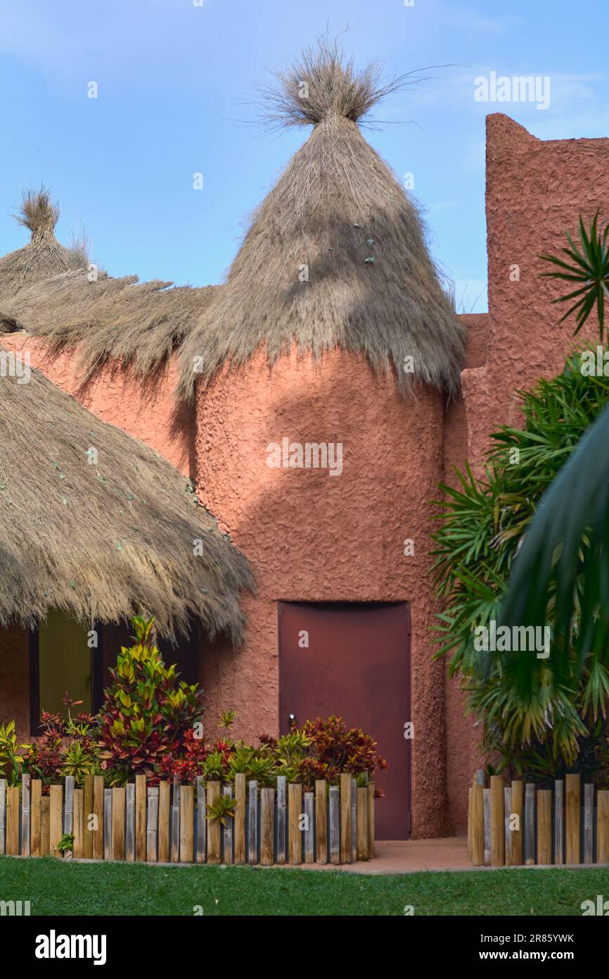 Mud house with a thatched roof and a beautiful garden at its entrance ...