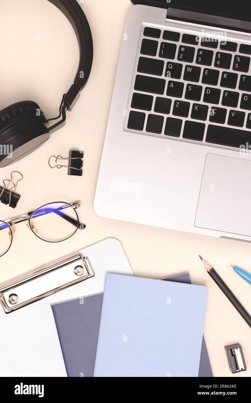 Laptop, headphones, eyeglasses and stationery on a beige background ...