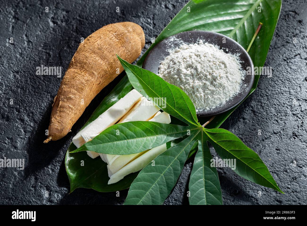 pile of cassava fruit and cassava flour on a background of rustic and ...