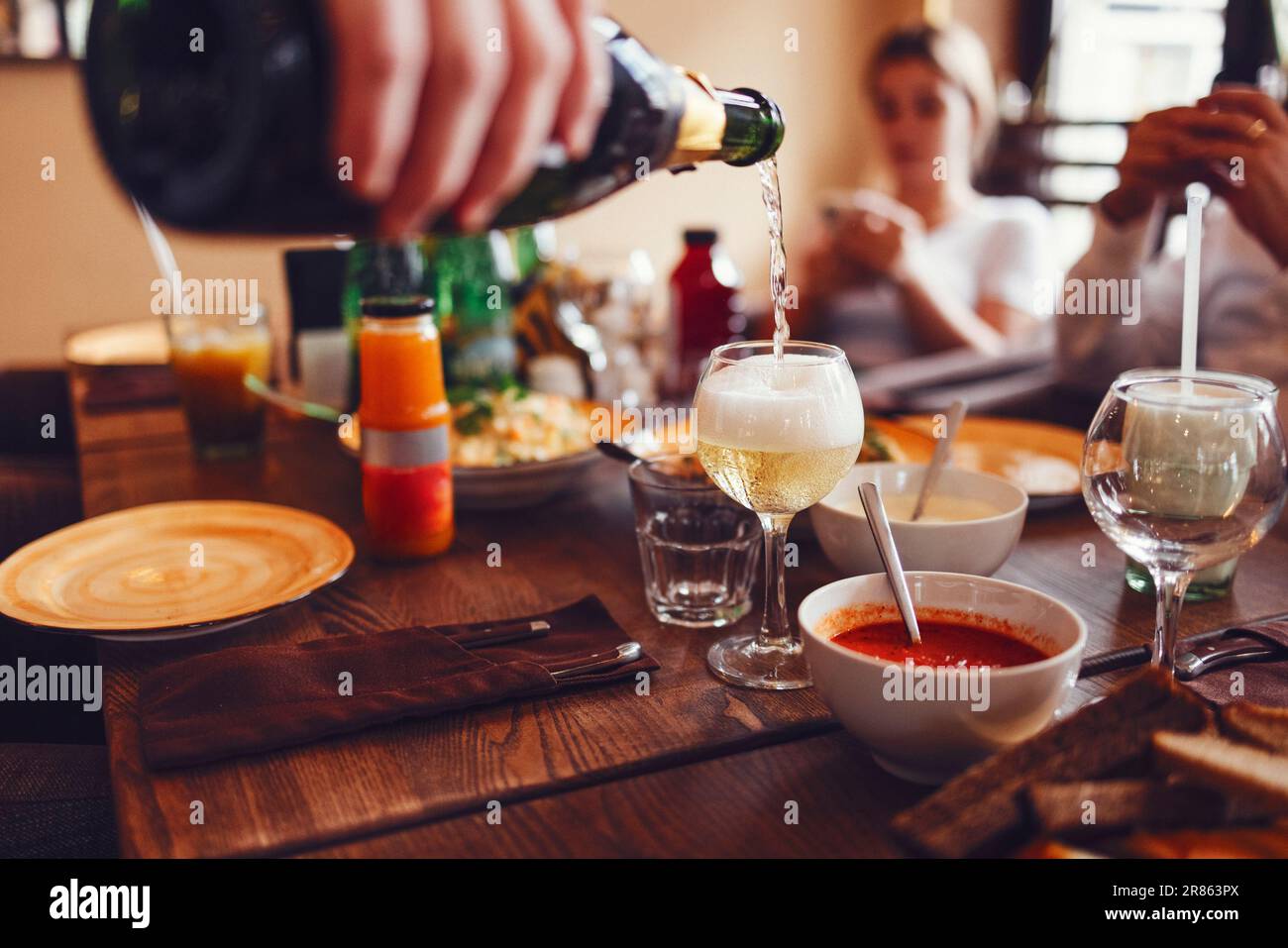 A man pours a glass of champagne. Close up of flowing sparkling wine ...