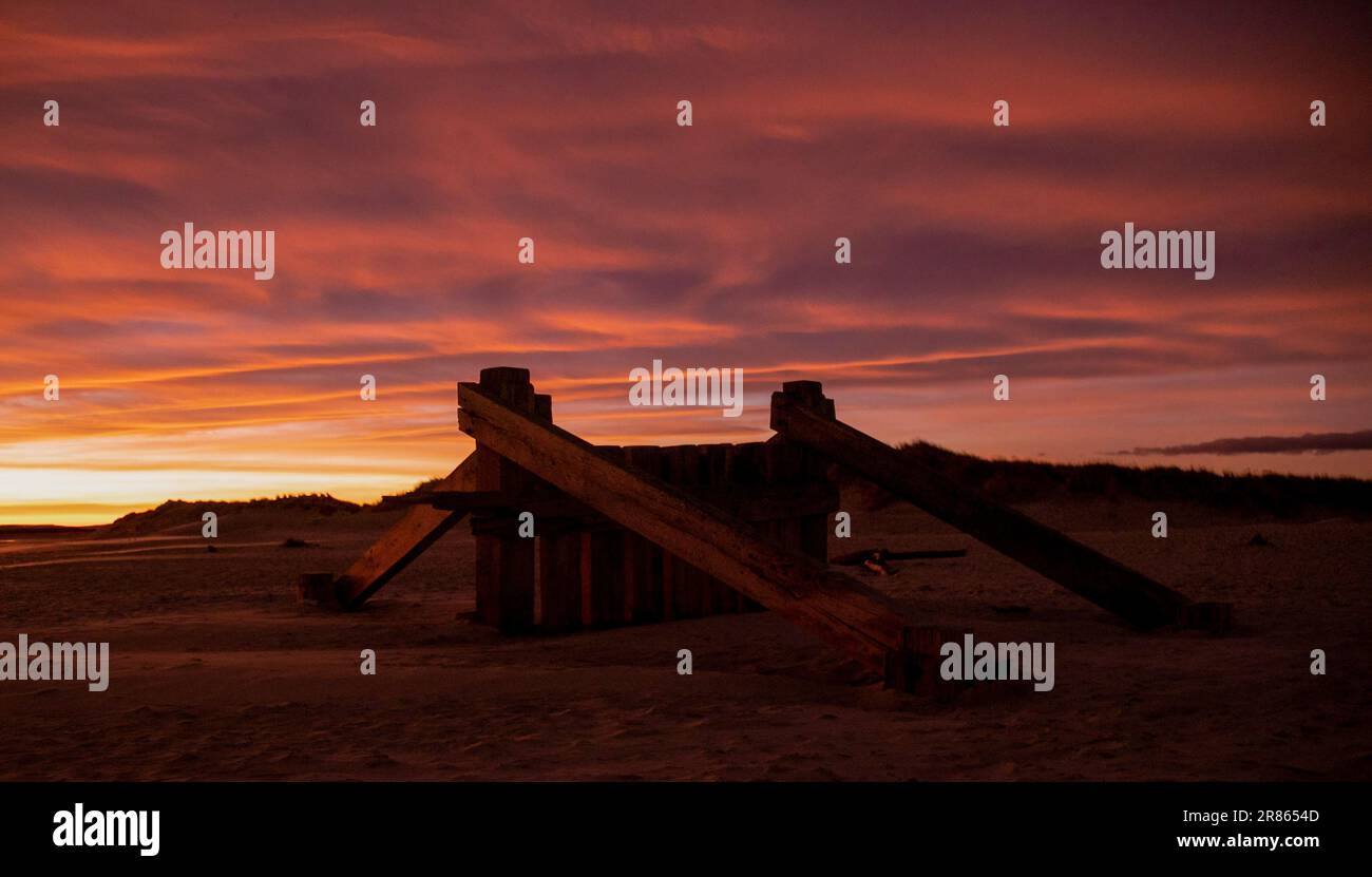 A wooden structure on the beach at scenic sunrise Stock Photo - Alamy