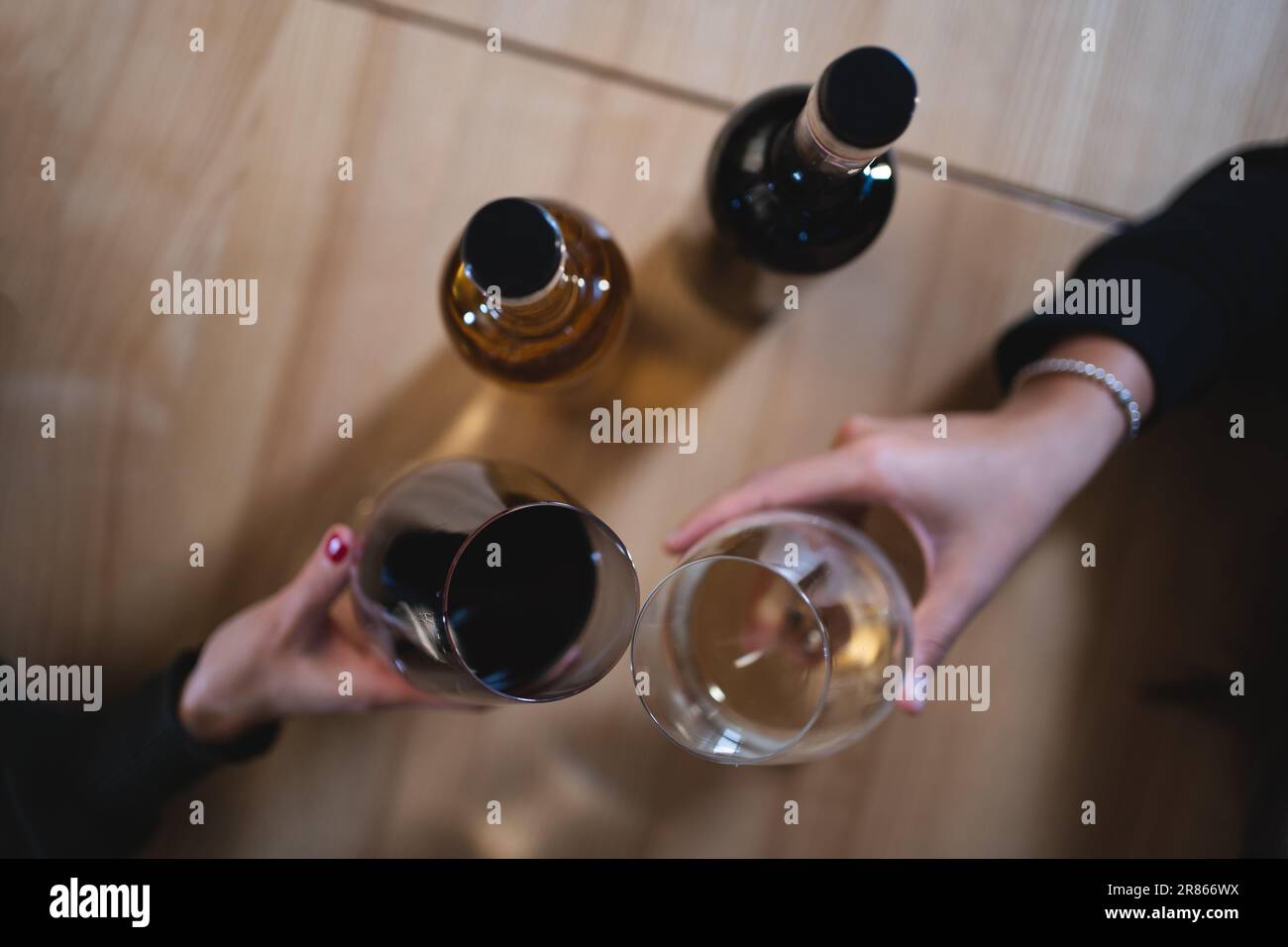 two person cheering and celebrate and drink red and white wine in ...