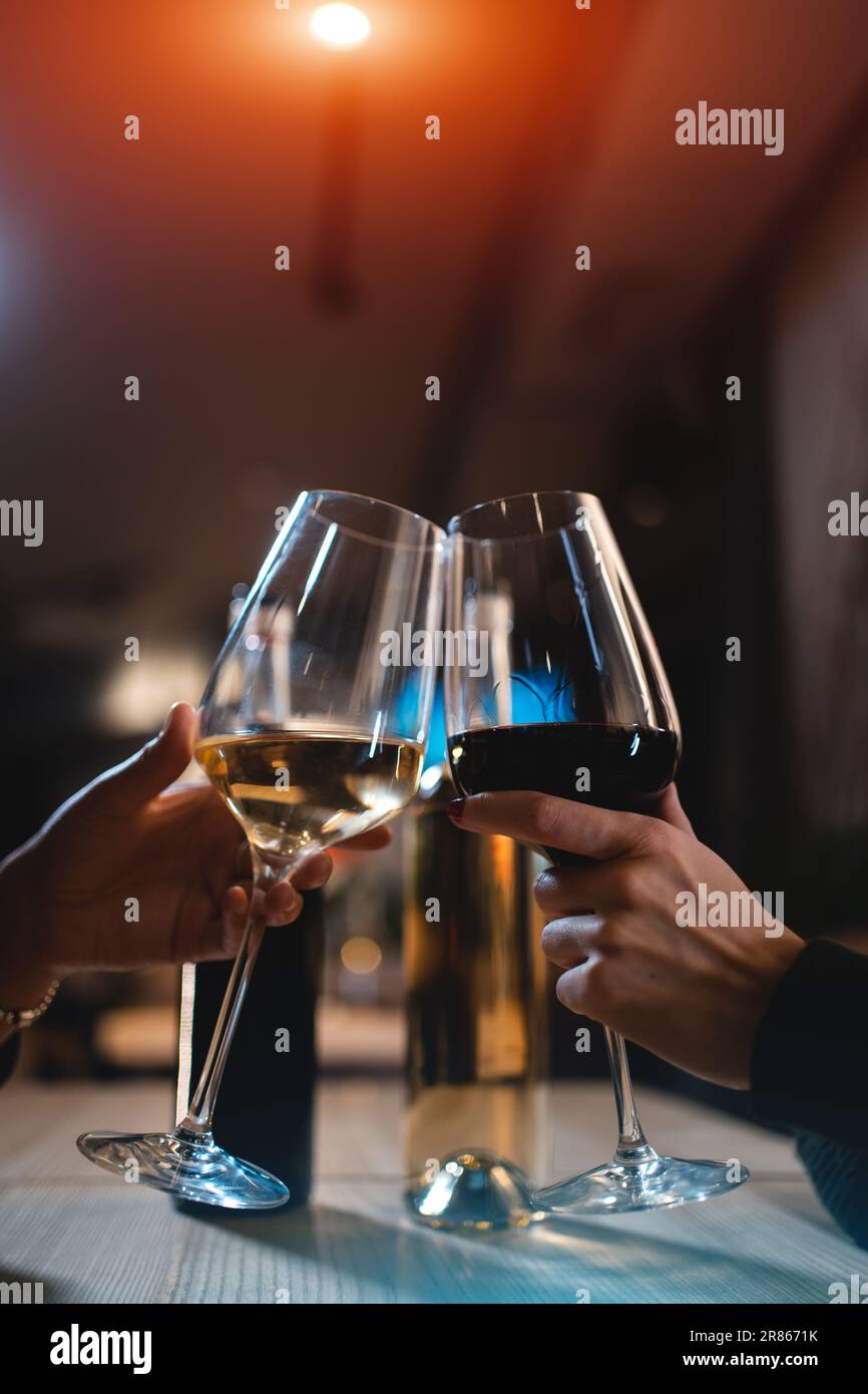 two person cheering and celebrate and drink red and white wine in ...