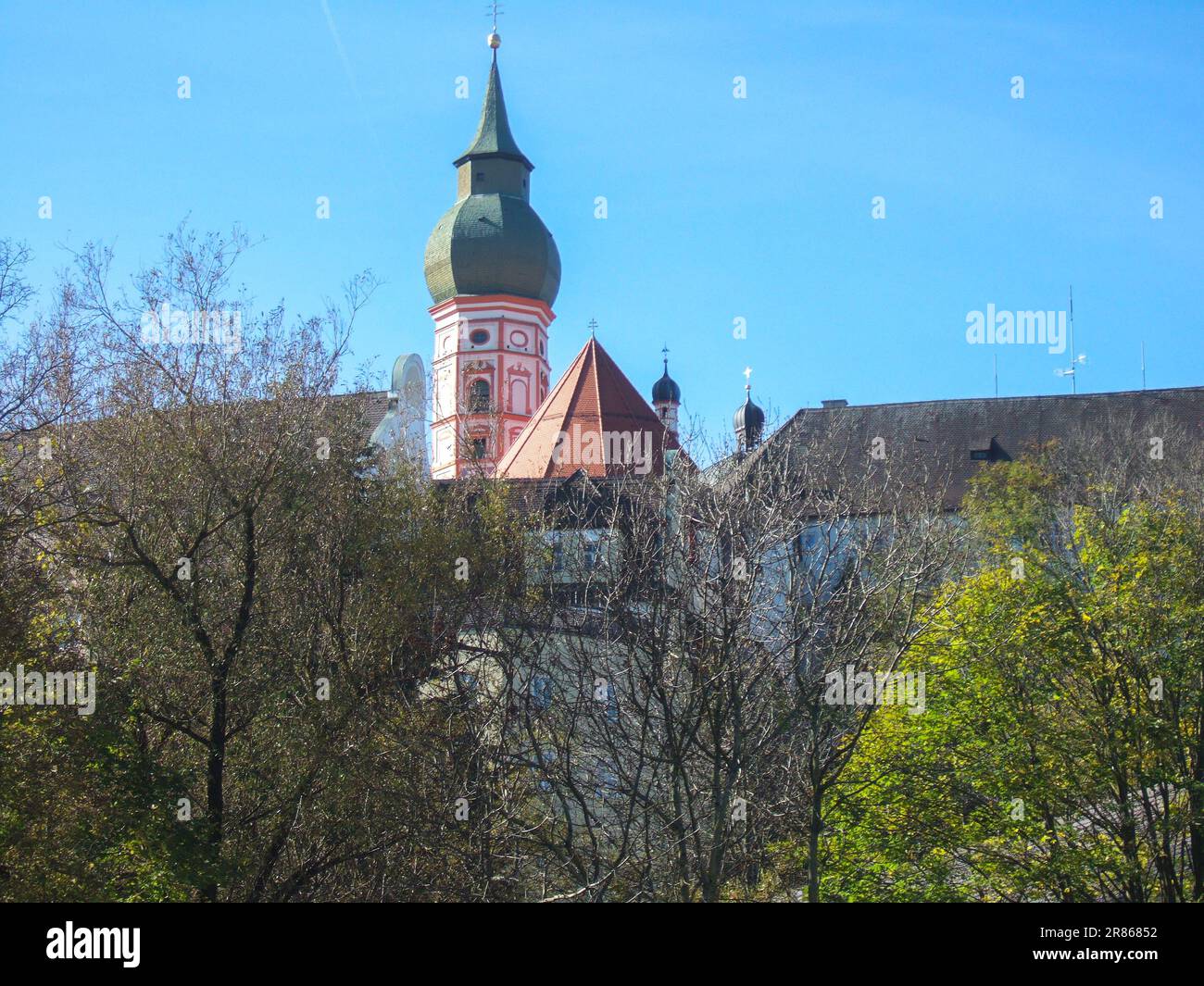 Red and white monastery church with green domed tower roof in Andechs ...